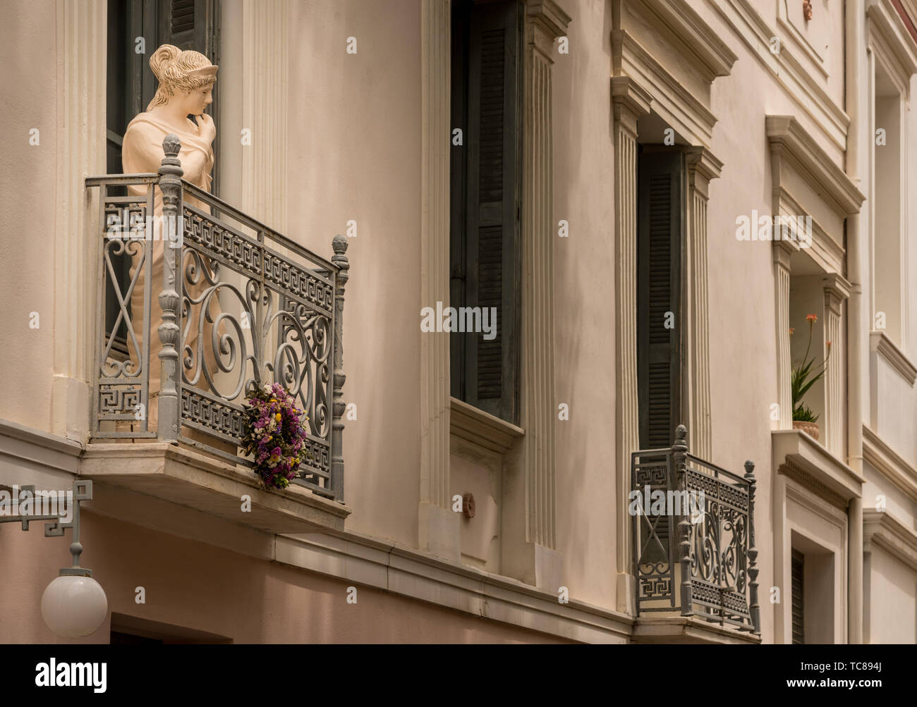 Statue on balcony of ancient residential district of Plaka in Athens ...