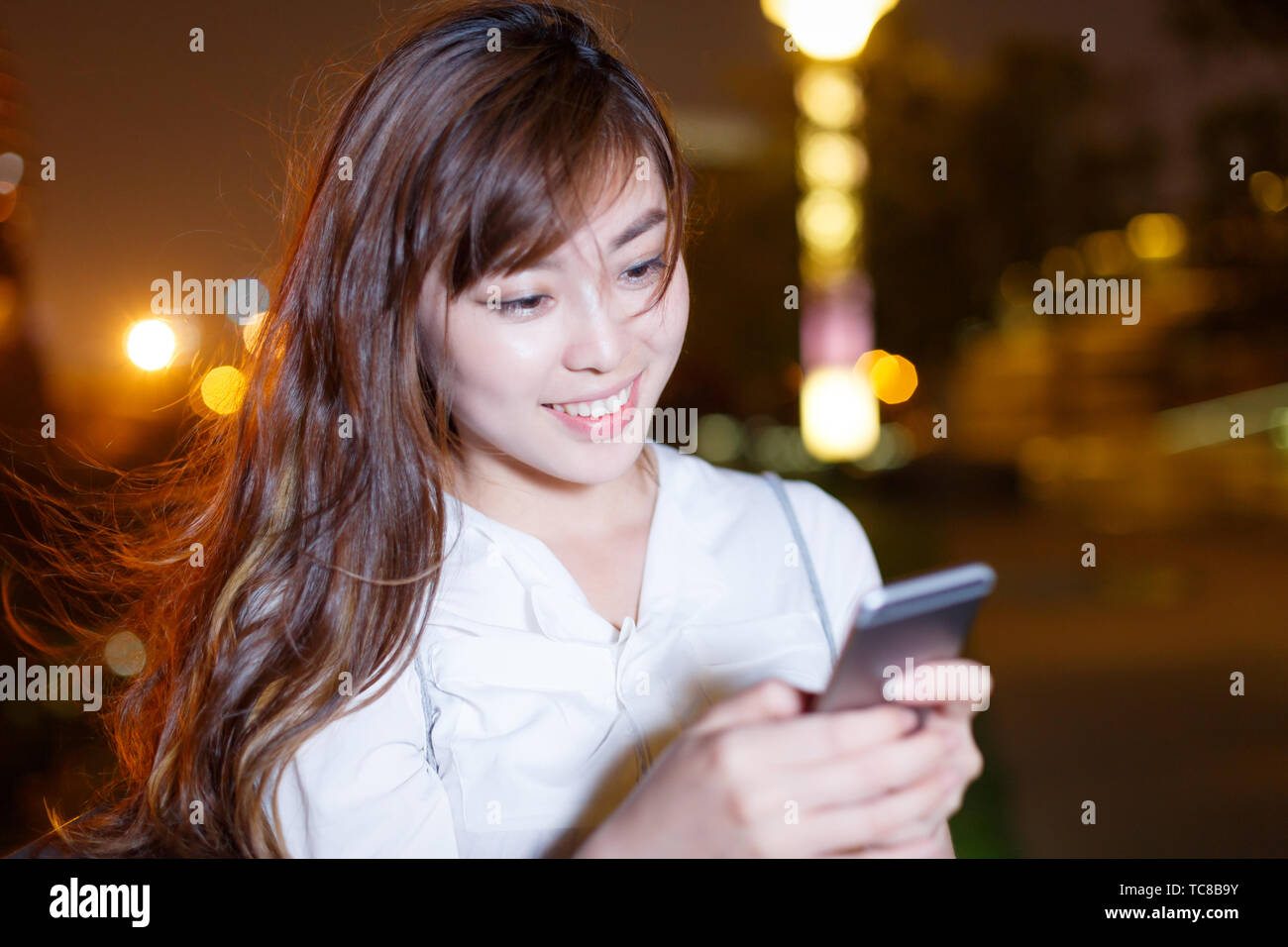 Asian female using smartphone night hi-res stock photography and images ...