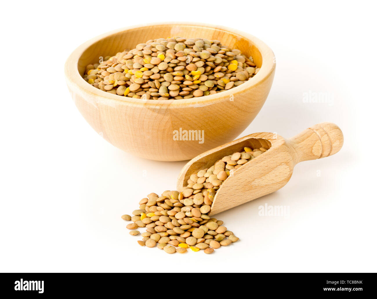 Raw, dry, uncooked brown lentil legumes in wooden bowl and wood scoop ...