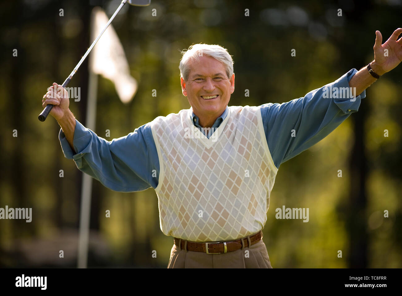 Happy older man cheering on golf course Stock Photo - Alamy