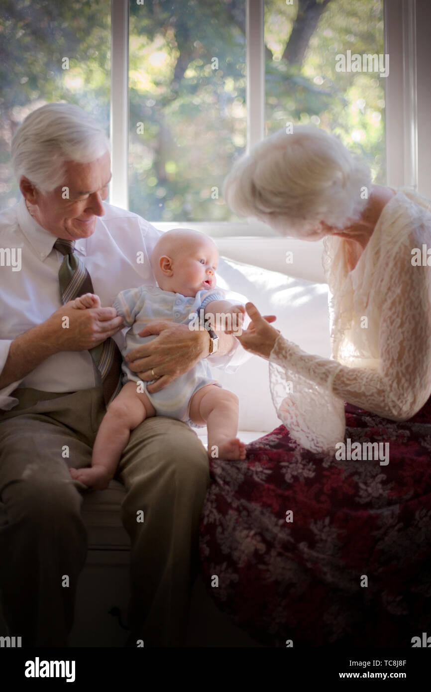 Senior couple sitting with their baby grandson Stock Photo - Alamy