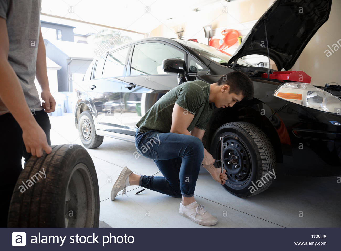 Person changing flat tire hi-res stock photography and images - Alamy