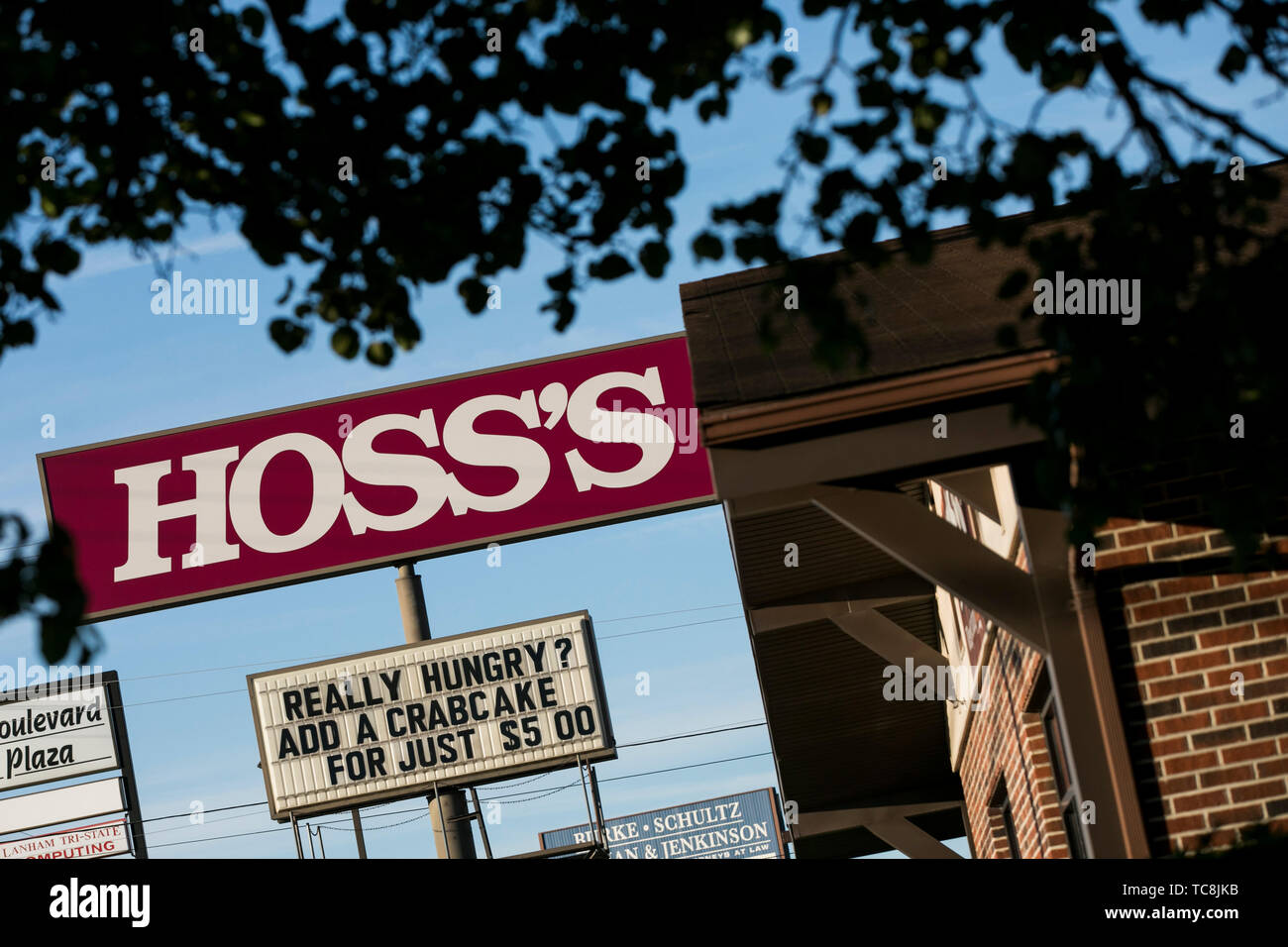 A logo sign outside of a Hoss's Family Steak and Sea restaurant ...