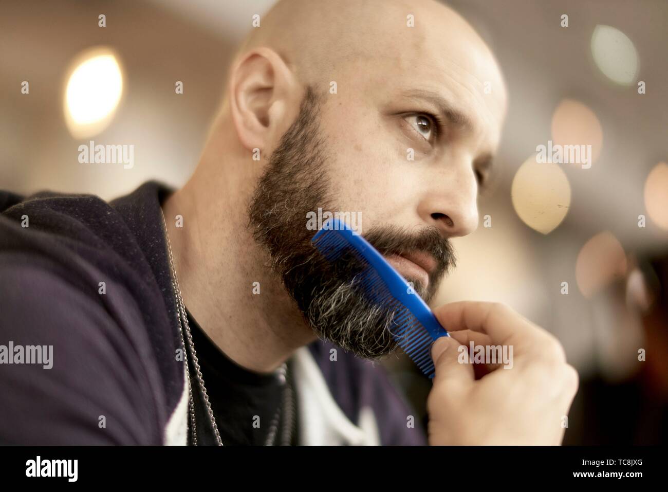 Man combing his beard Stock Photo - Alamy