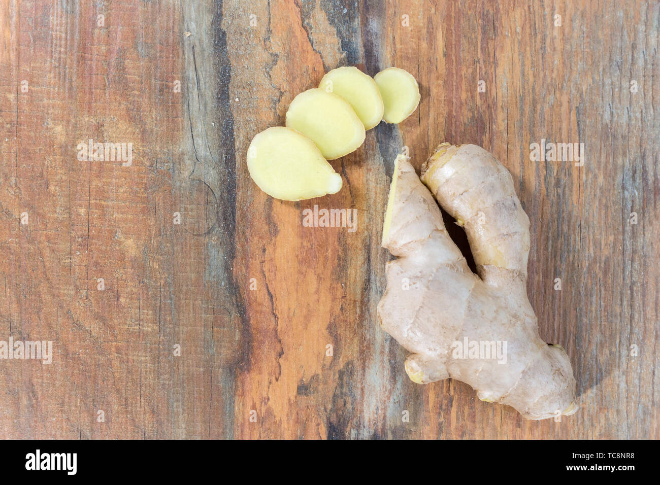 Ginger and cut ginger slices on table Stock Photo - Alamy