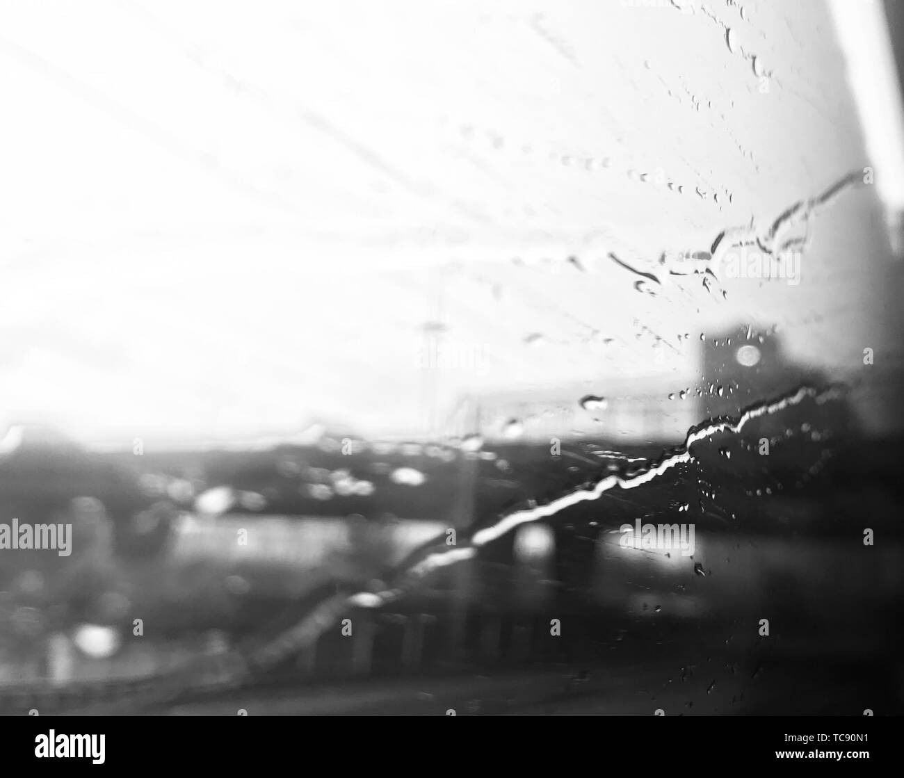 A person, a car, rain hits the window and maps the landscape out of the ...