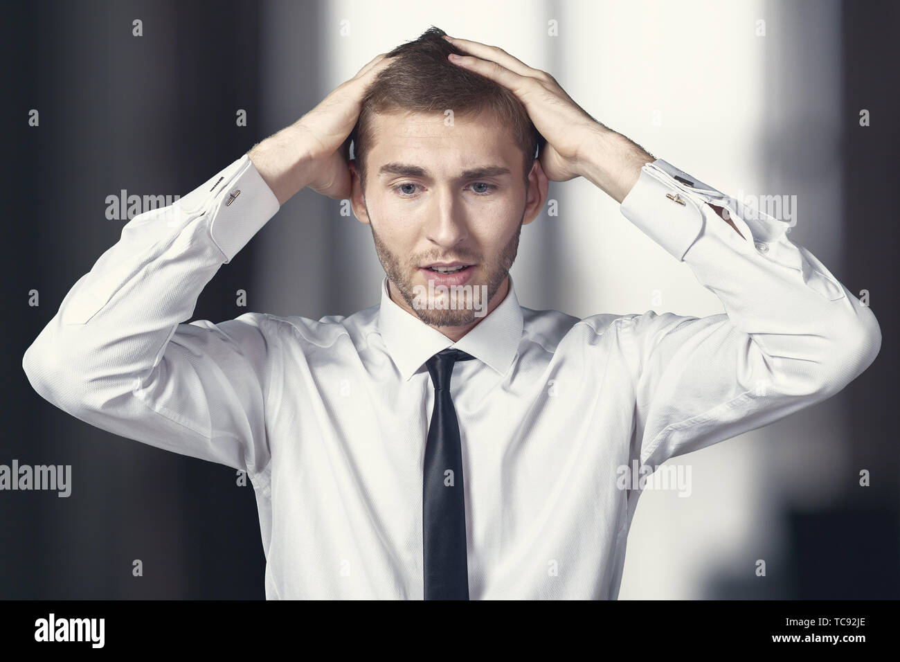 Confused young businessman thinking Stock Photo - Alamy