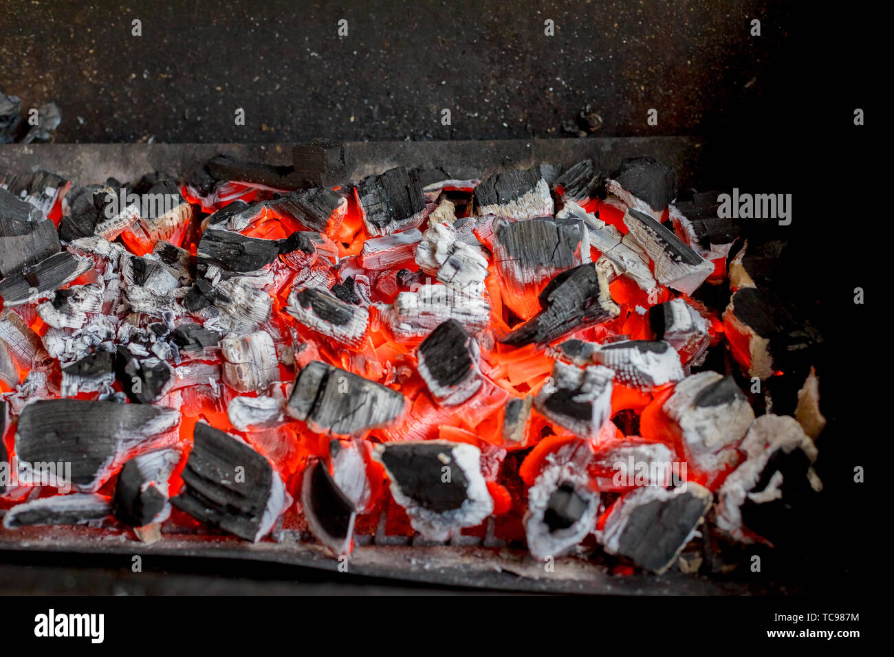 Bright hot coals and burning woods in bbq grill pit. Glowing and ...