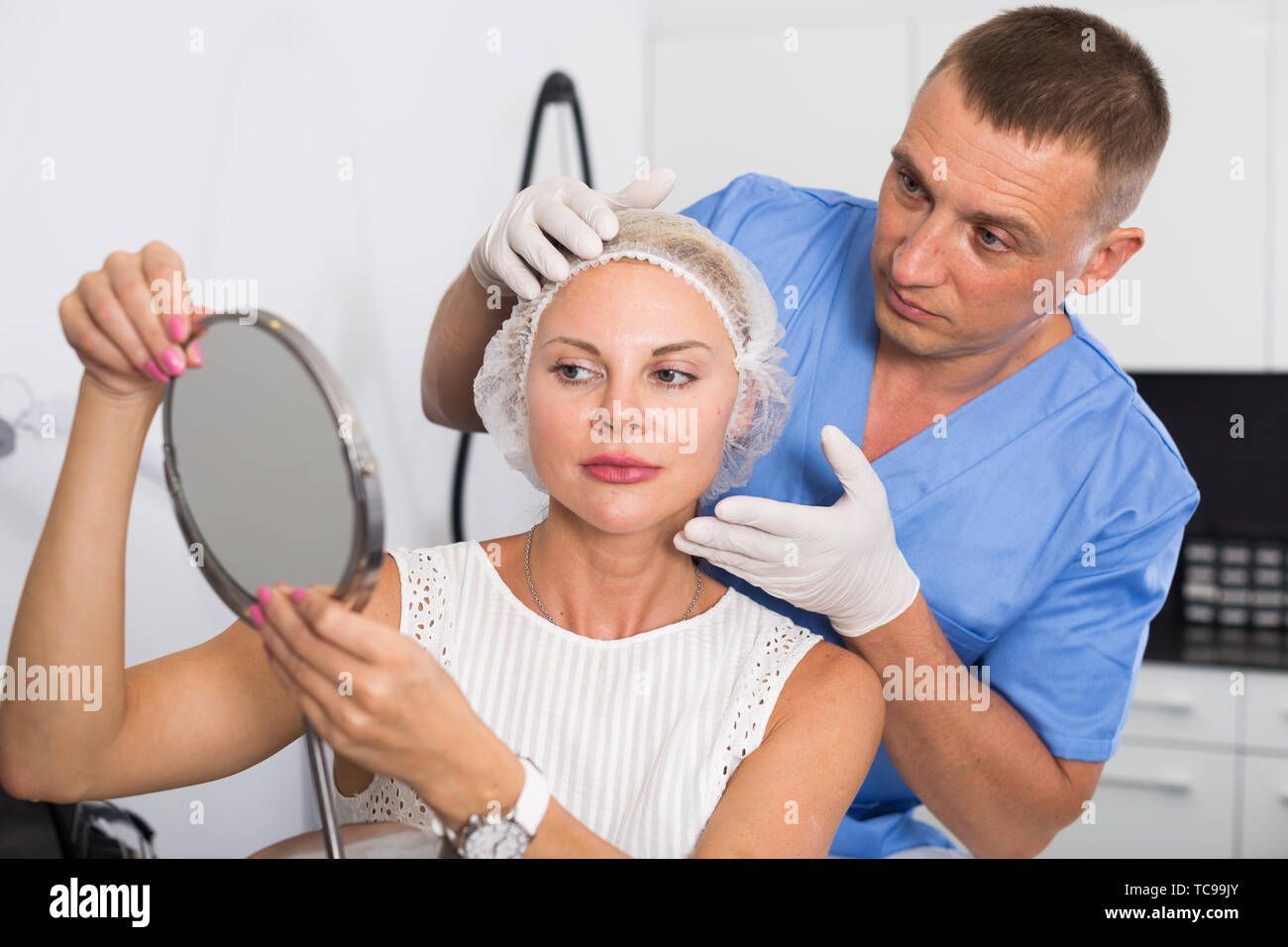 Man doctor is preparing female patient to procedure in cabinet Stock ...