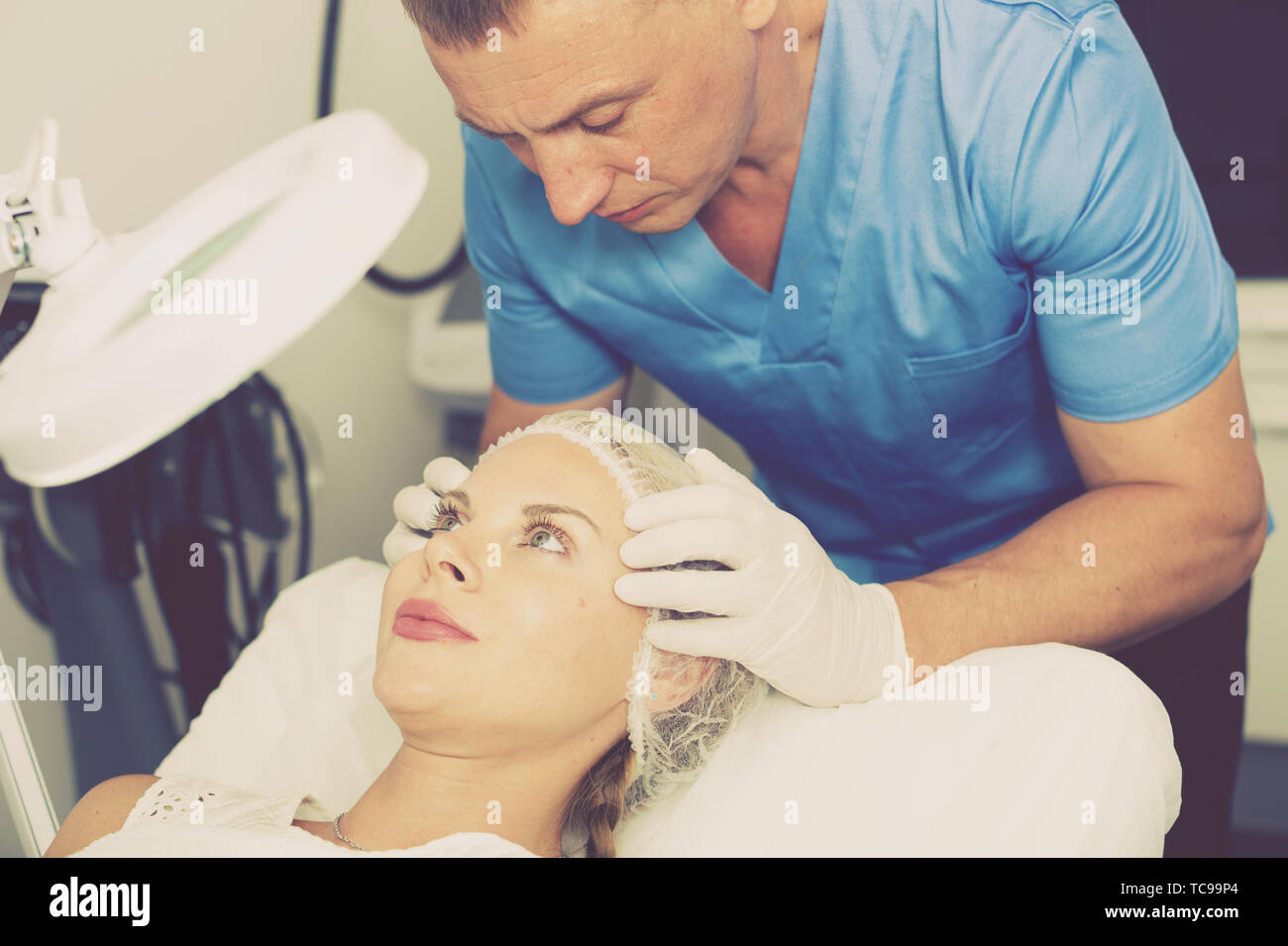 Doctor is examining woman patient before the procedure in estetic clinic Stock Photo - Alamy