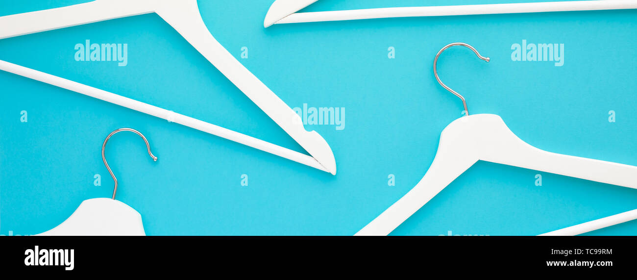 Creative top view flat lay white wooden hangers isolated bold blue ...