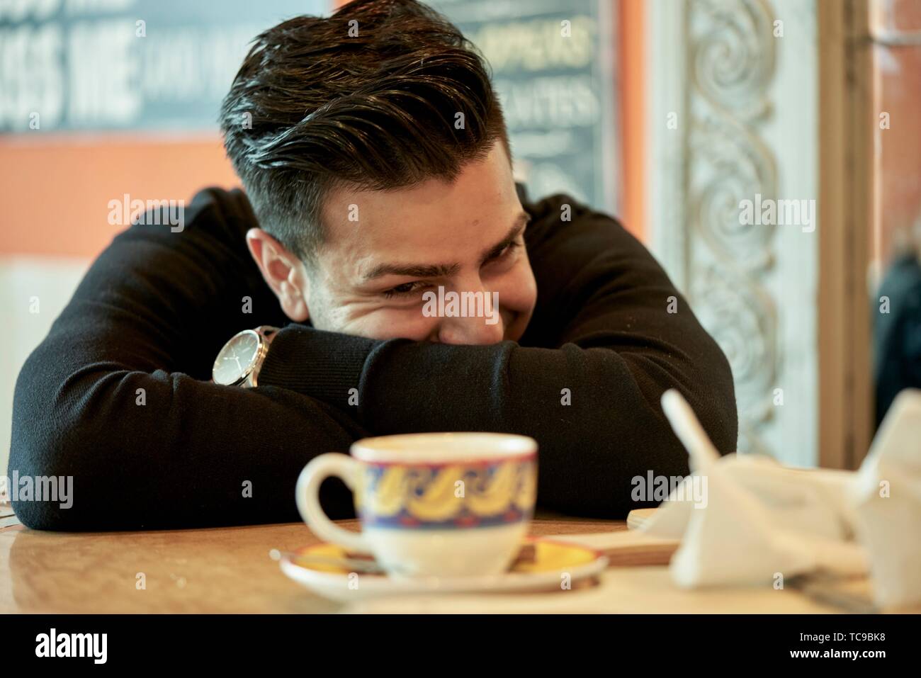 young witty man taking afternoon break indoors, tea-time, in café, in ...