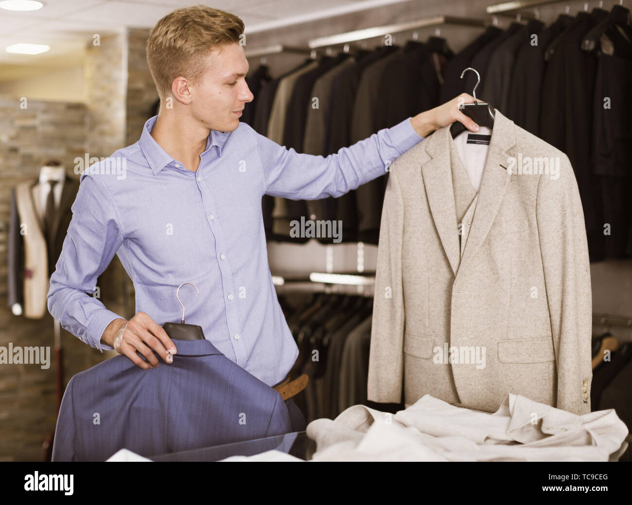 Portrait of man buyer choosing business style jacket in the shop Stock ...