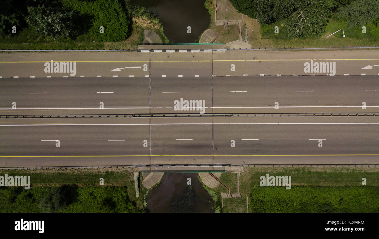 Top down close up of highway, white arrow signs indicating direction ...