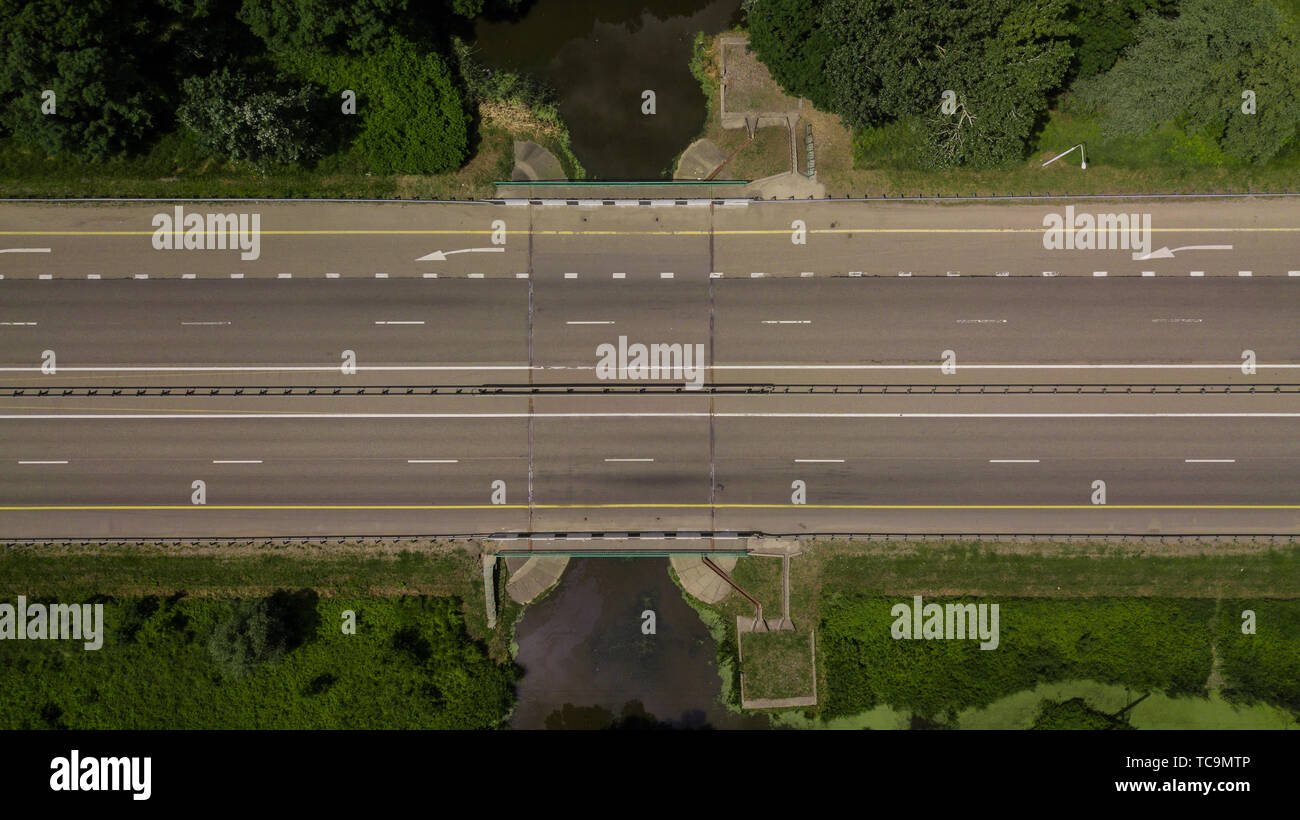 Top down close up of highway, white arrow signs indicating direction ...