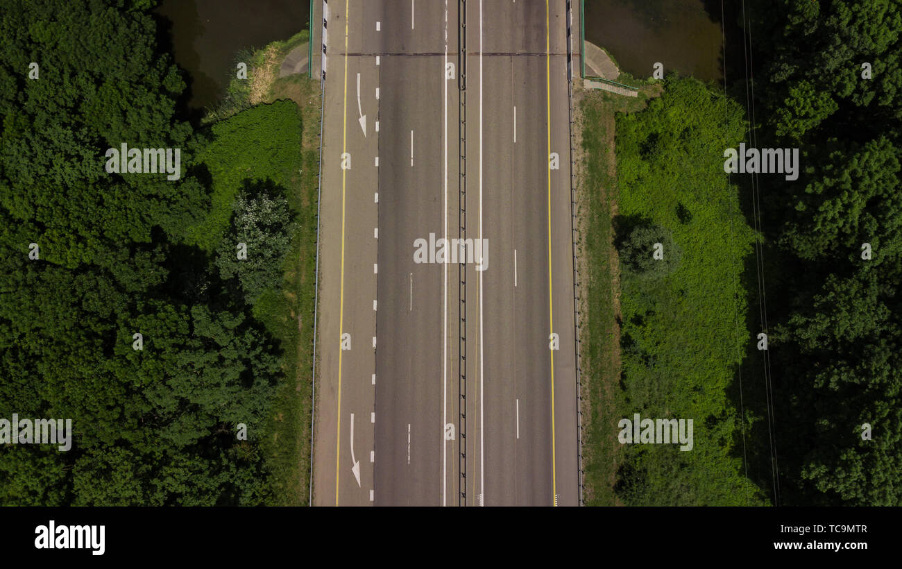 Top down close up of highway, white arrow signs indicating direction ...
