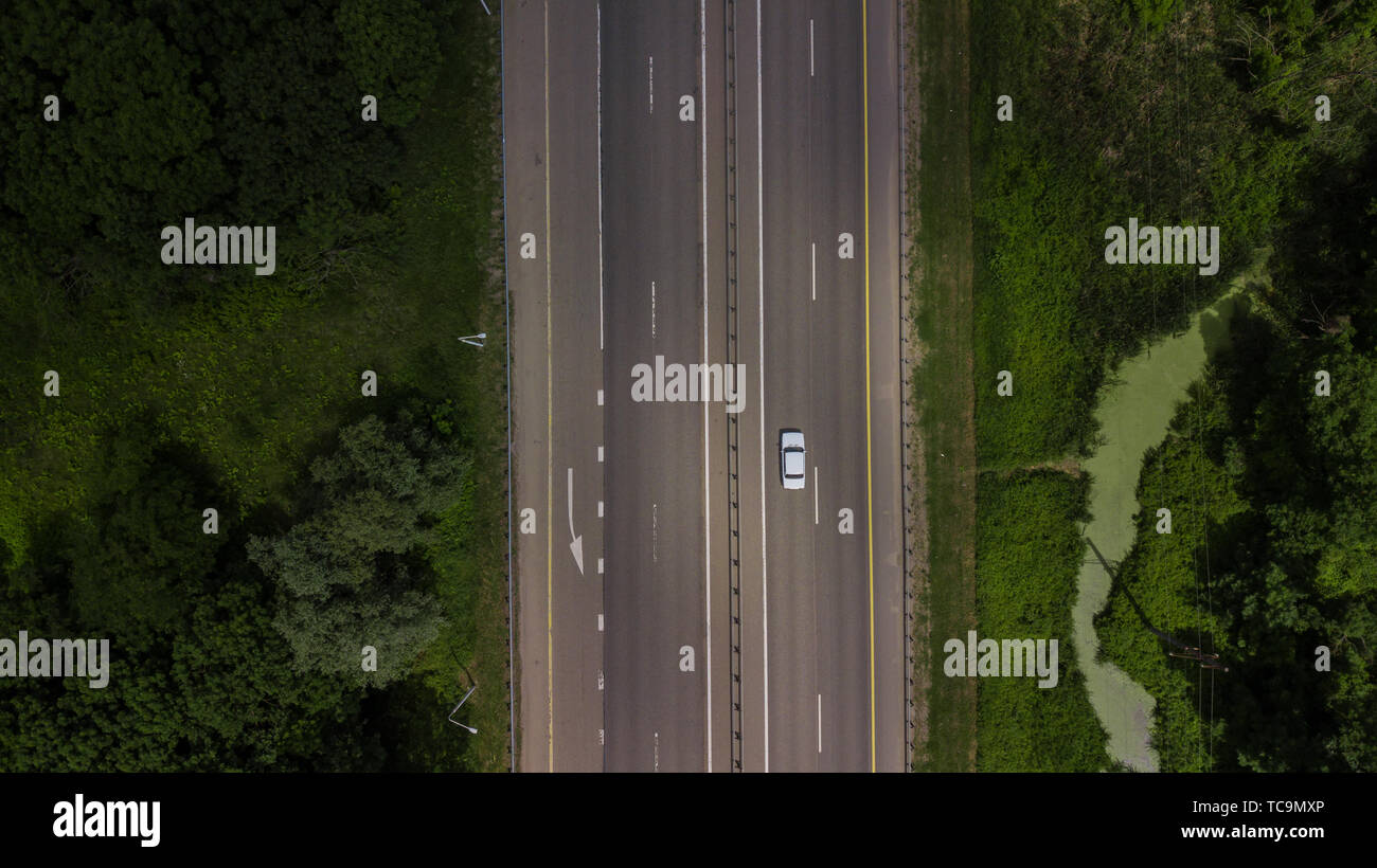 Top down close up of highway, white arrow signs indicating direction ...