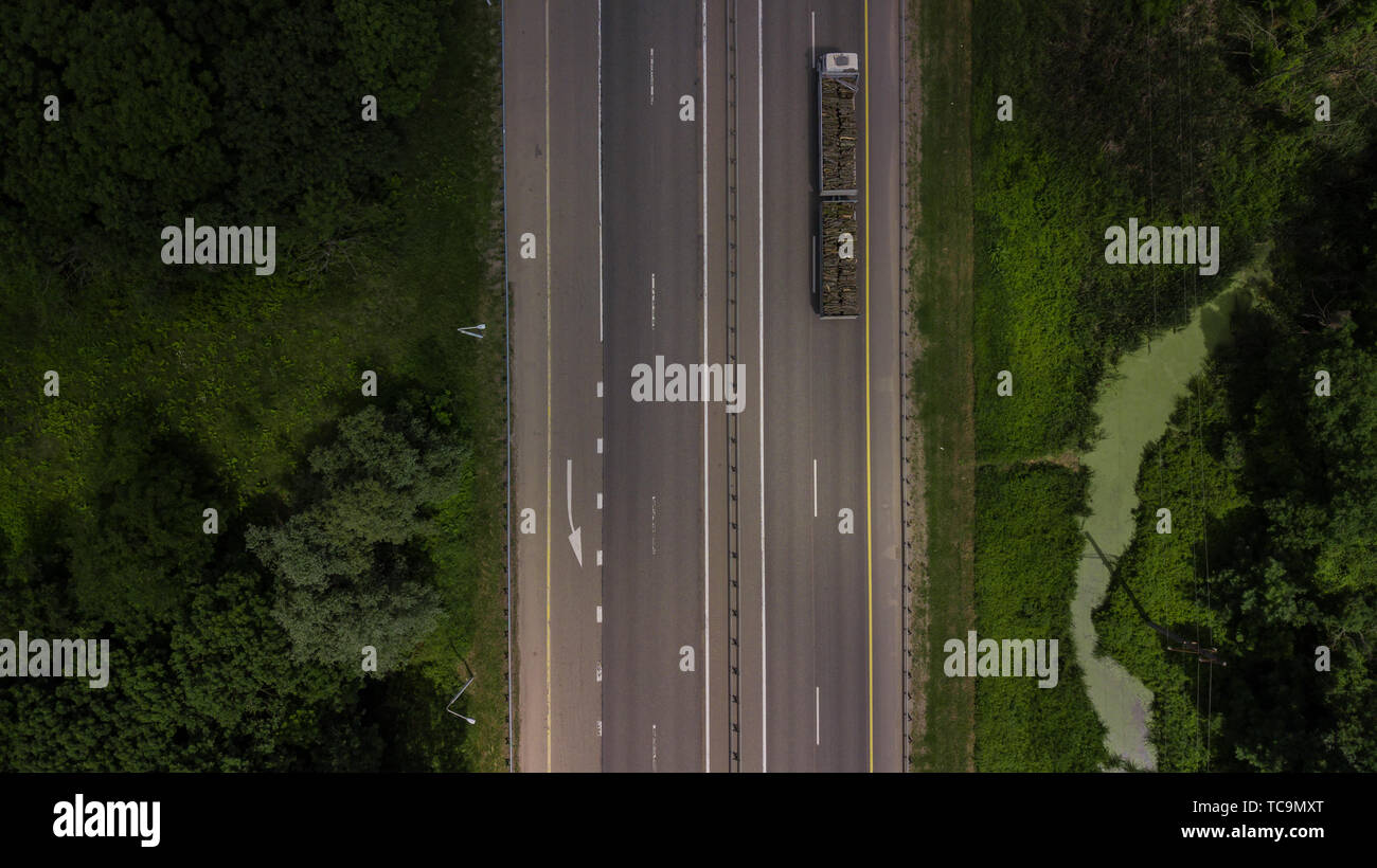 Top down close up of highway traffic with truck, white arrow signs ...