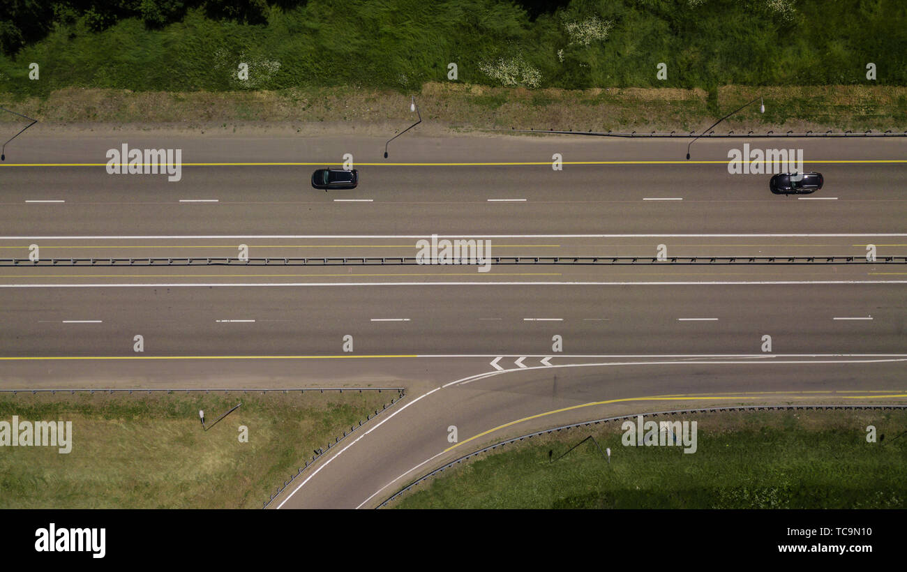 Top down close up of highway, white arrow signs indicating direction ...