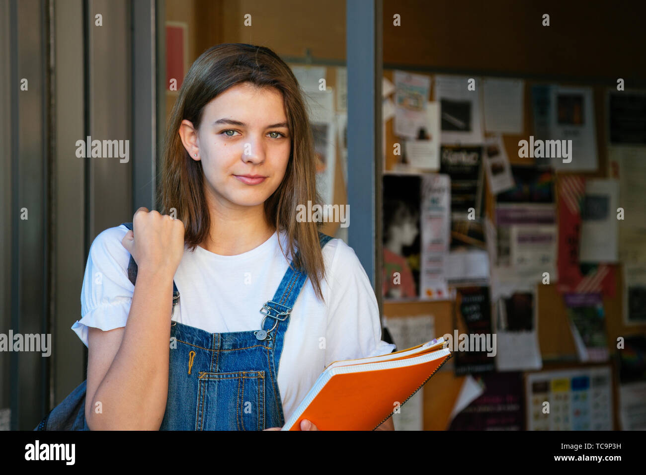 Portrait of a beautiful student girl at the school entrance with ...