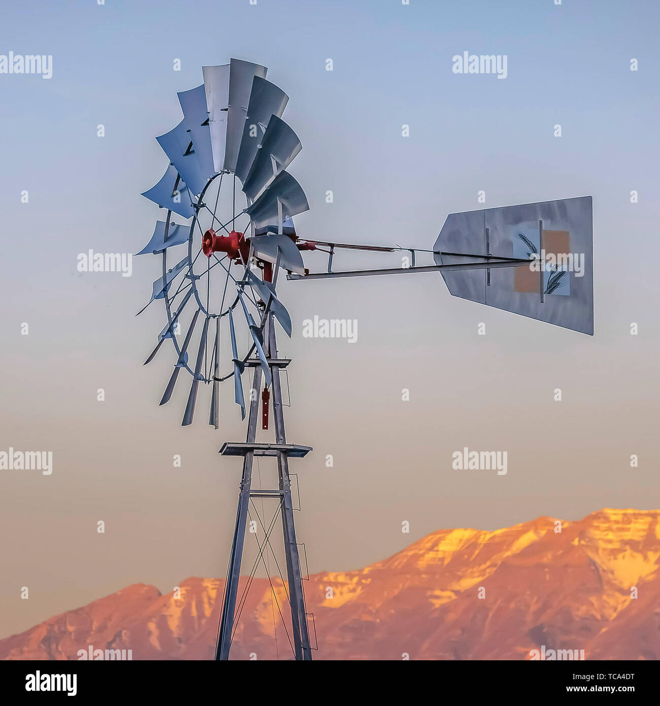 Square Windpump with a rugged golden mountain and cloudy sky background ...