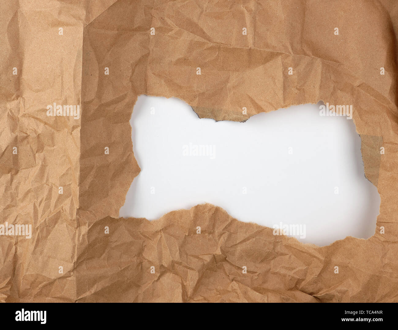 round torn hole in brown paper, white background, close up Stock Photo ...