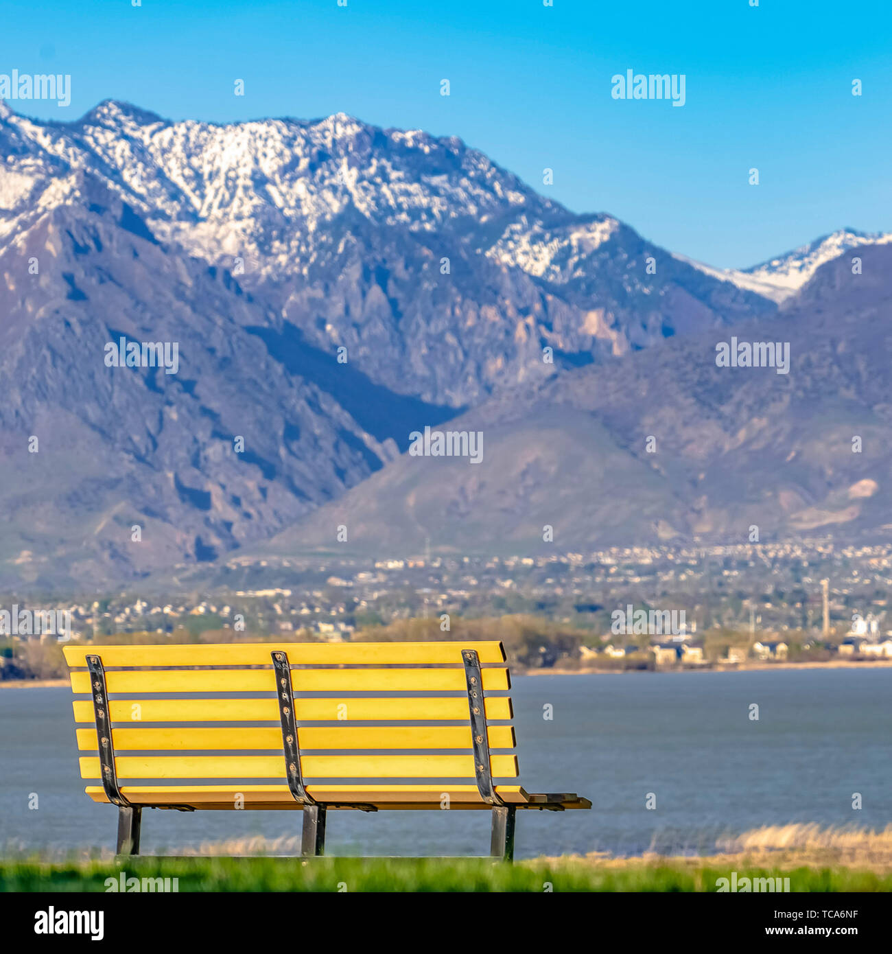 Frame Square Empty bench facing an amazing view of a lake and mountain ...