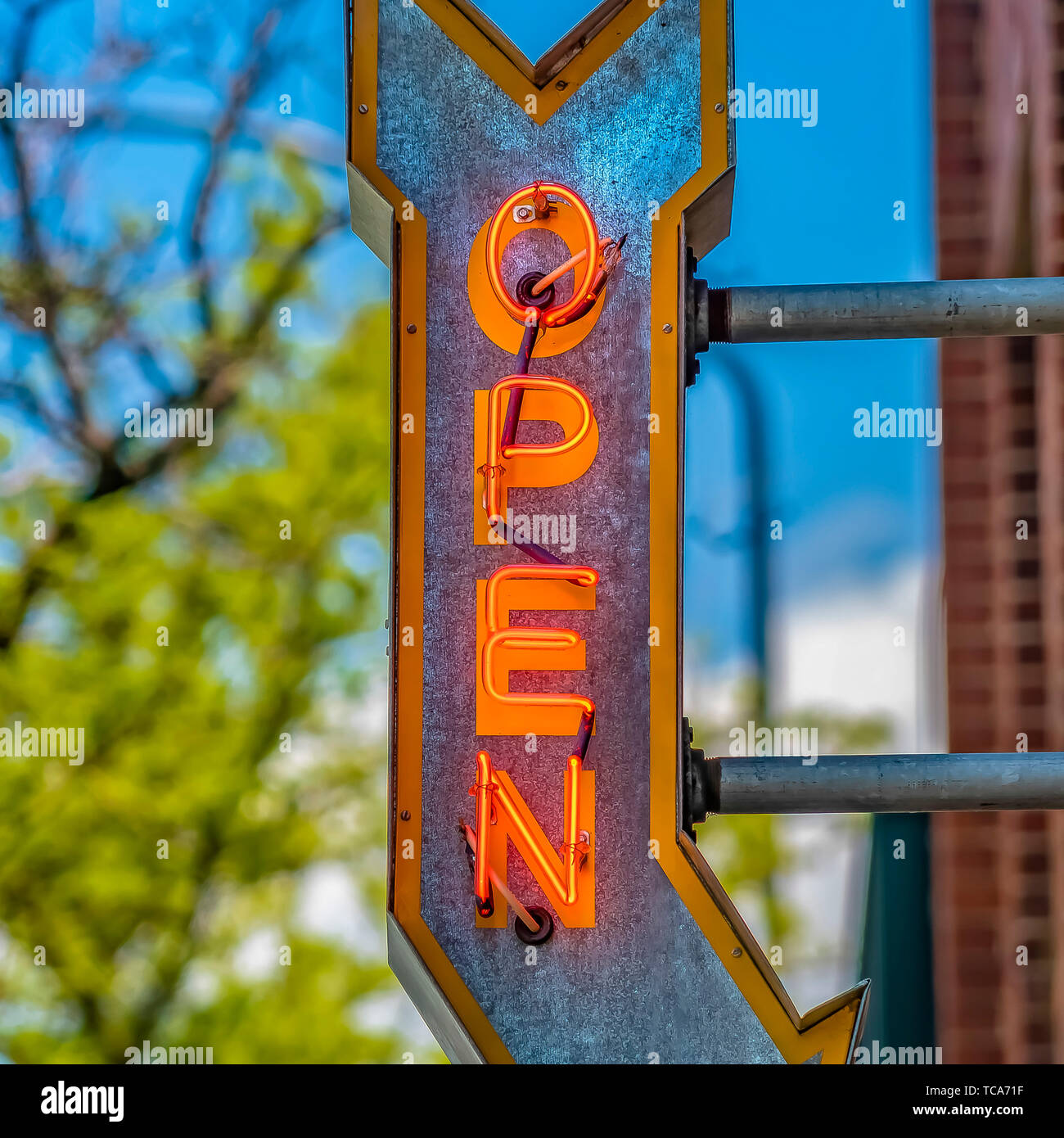 Square Red brick building with an Open arrow sign viewed on a sunny day ...