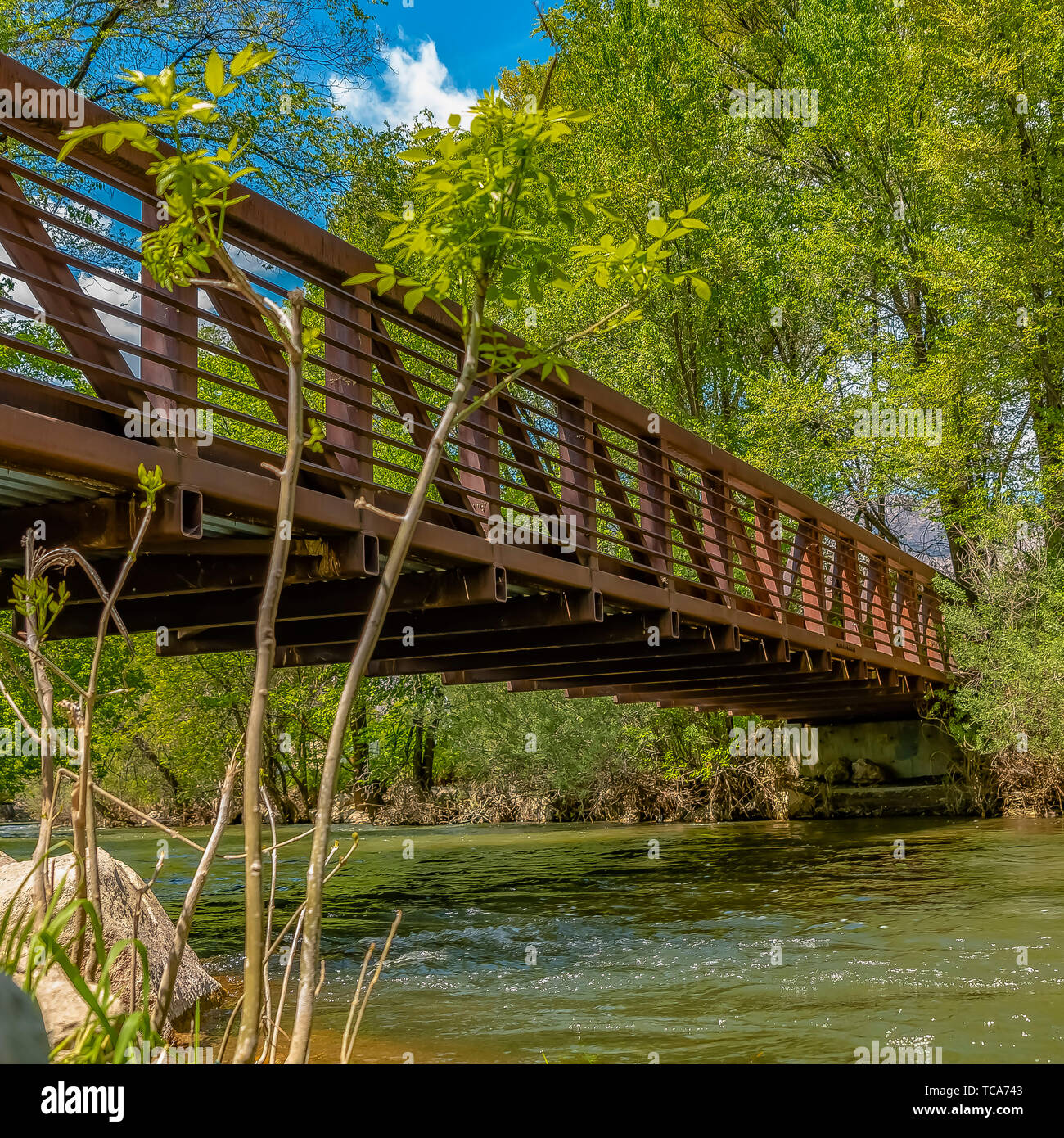 Frame Square Bridge with metal guardrails over the glistening water at ...