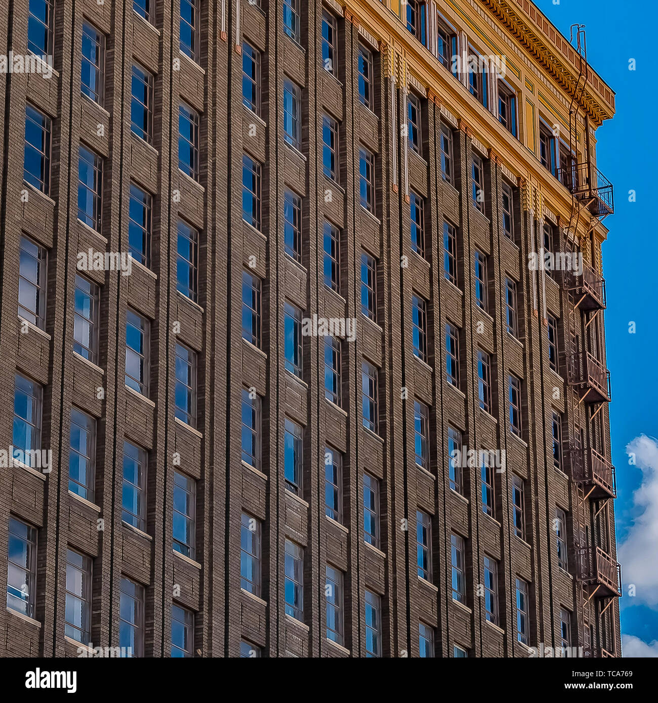 Square Exterior of a building with the cloudy blue sky reflected on the ...