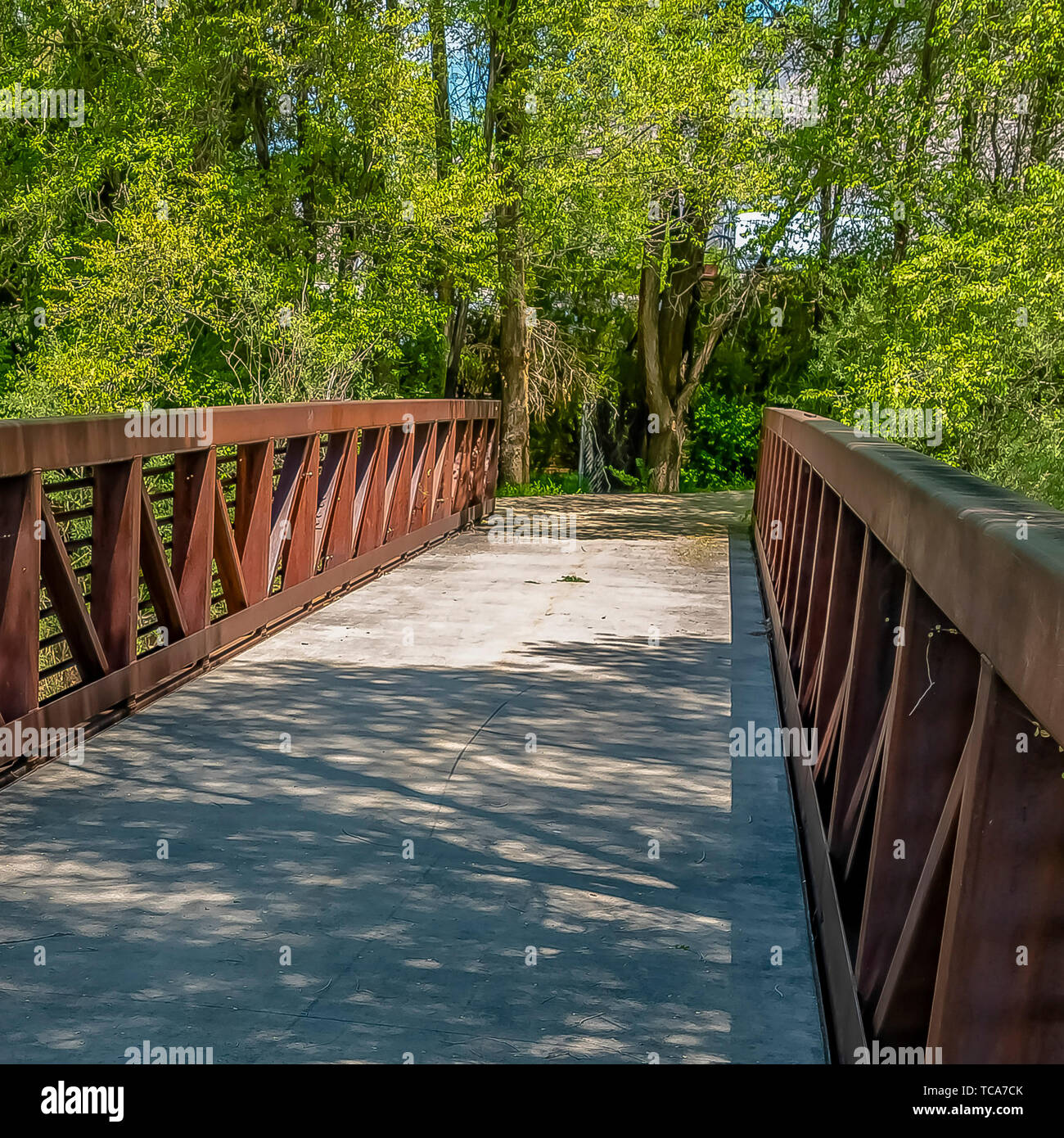 Square Bridge with brown guardrails overlooking a river and abundant ...