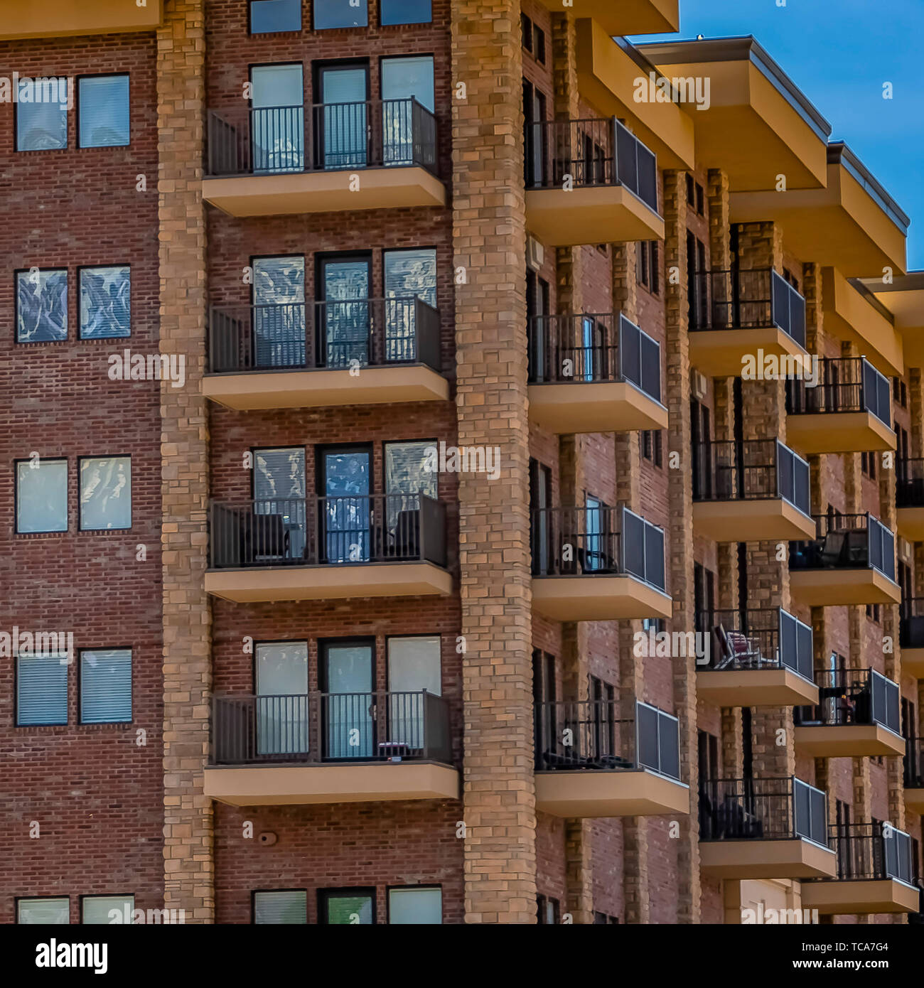 Frame Square Residential brick building with balconies against blue sky ...