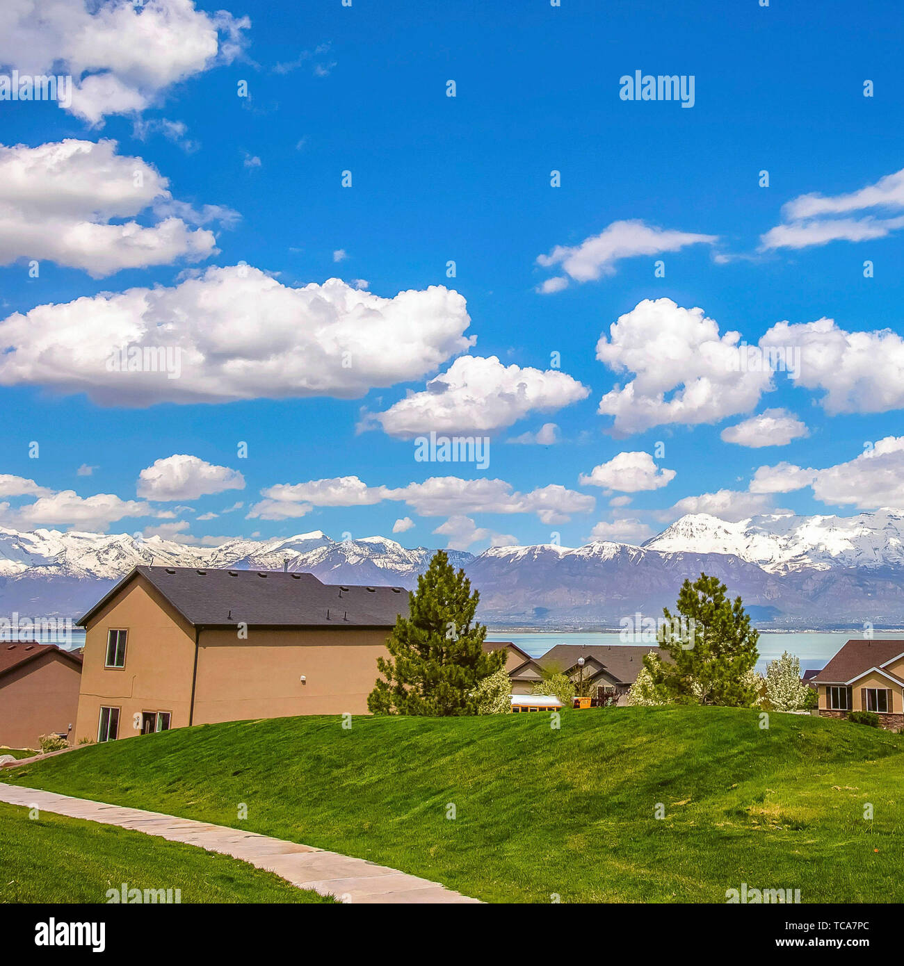 Square Pathway on a vast grassy terrain leading to the houses in front ...