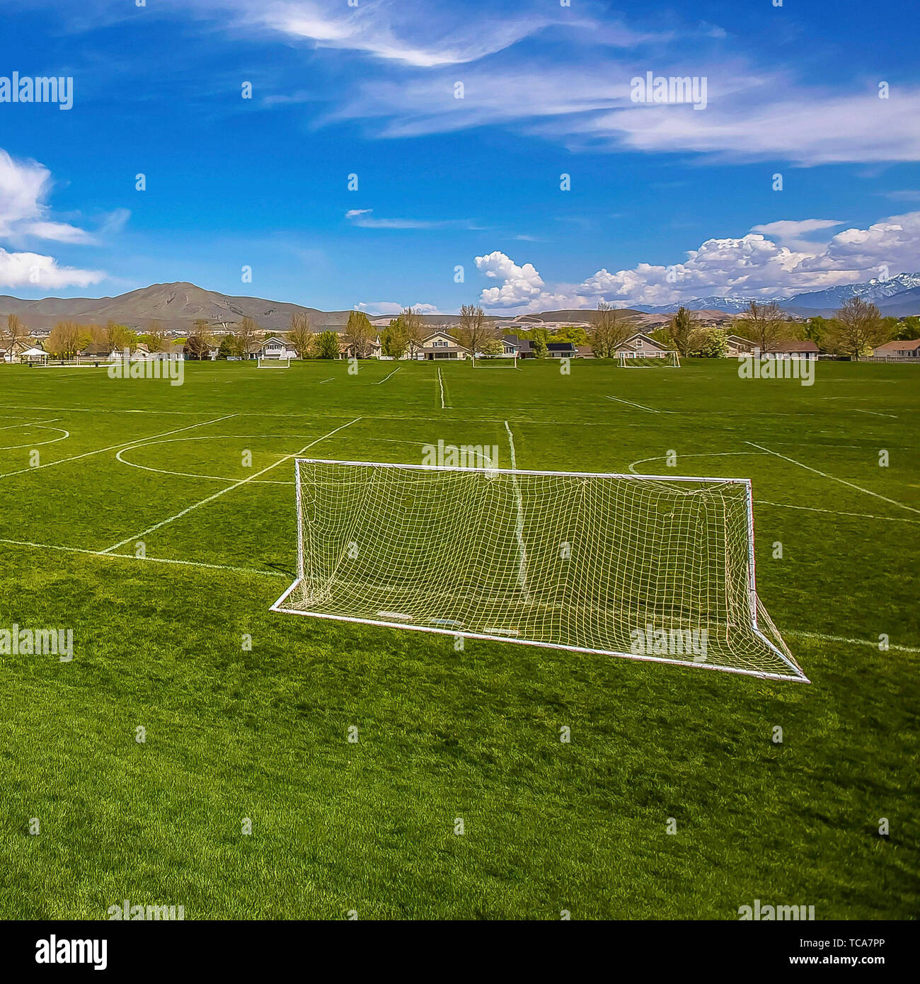 Frame Square Panorama of a soccer field with houses and mountain in the ...
