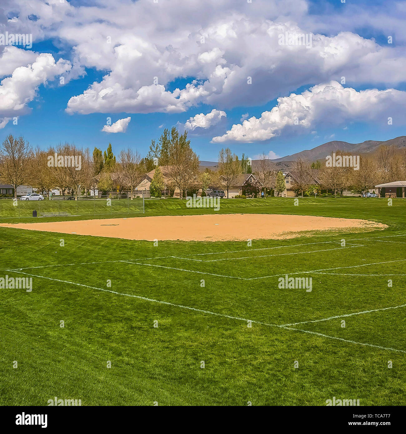 Frame Square Baseball or softball field with buildings and trees beyond ...