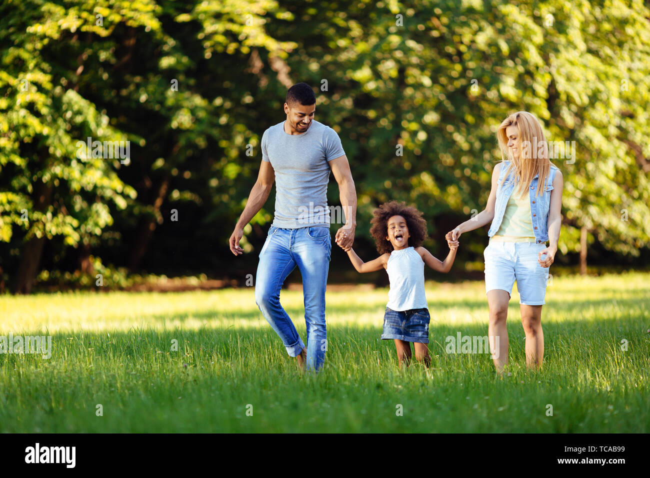 Happy young couple spending time with their daughter Stock Photo - Alamy