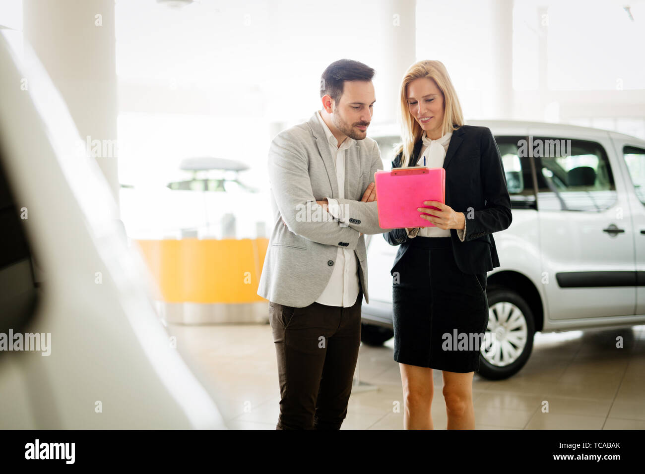 Professional salesperson selling cars at dealership to buyer Stock ...
