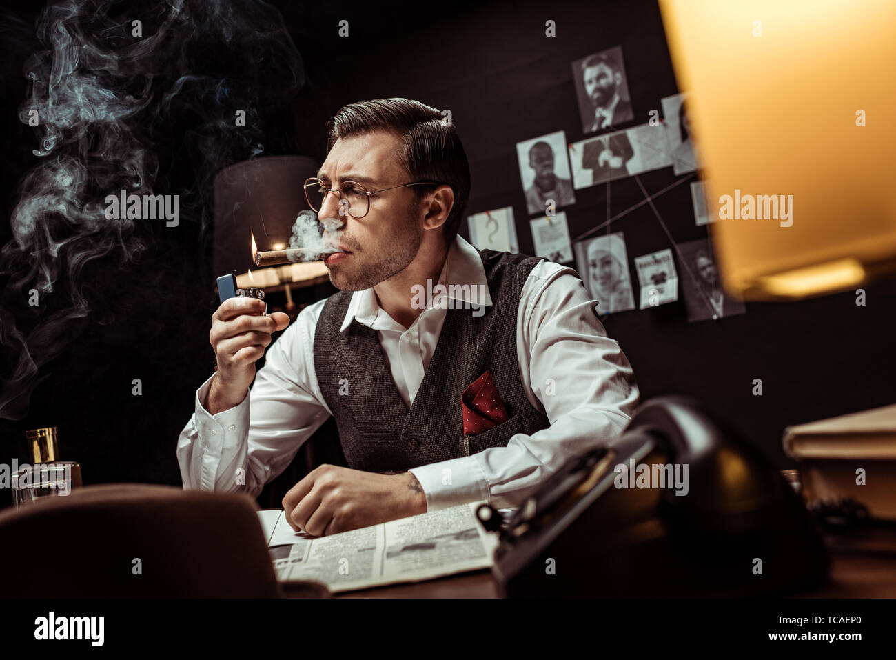 Detective in glasses and white shirt lighting cigar in dark office ...
