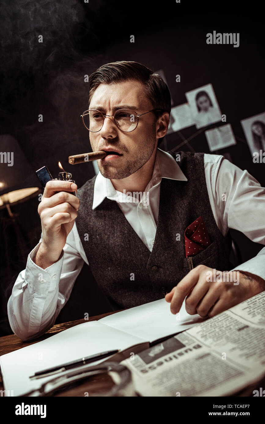 Detective in glasses and white shirt lighting cigar in dark office ...