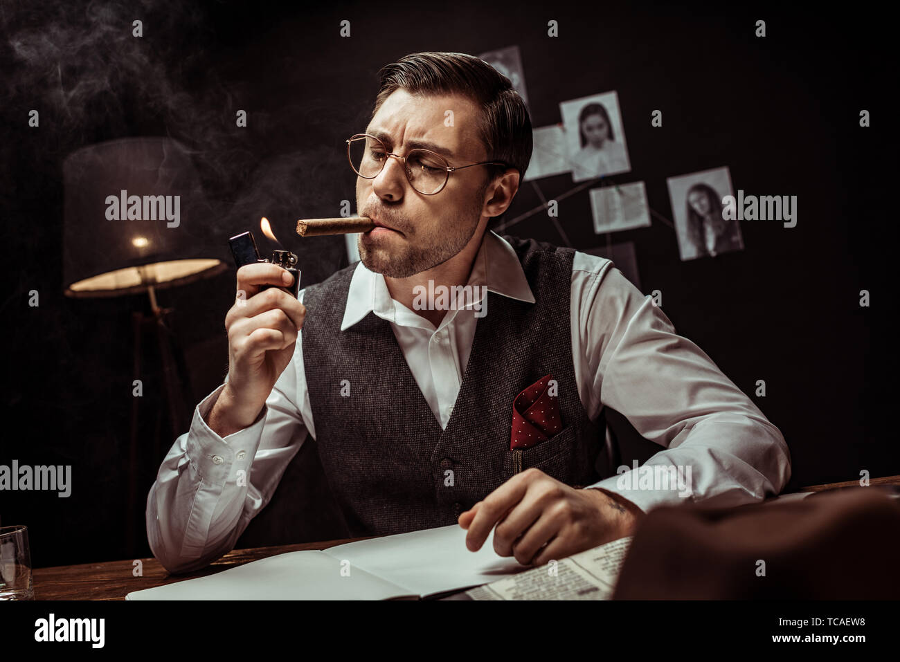 Detective in glasses and white shirt lighting cigar in dark office ...