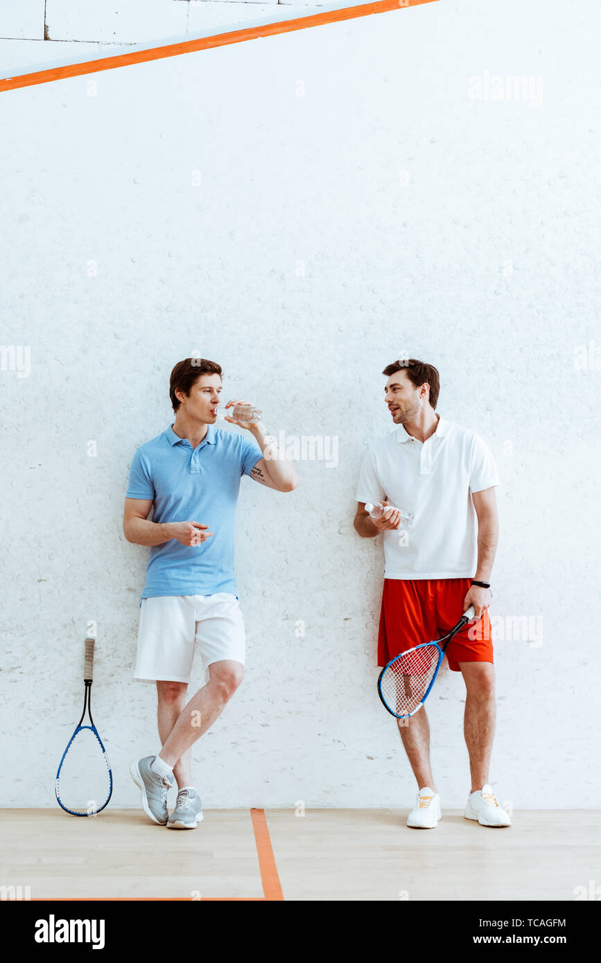 Full length view of squash players talking in drinking water Stock ...