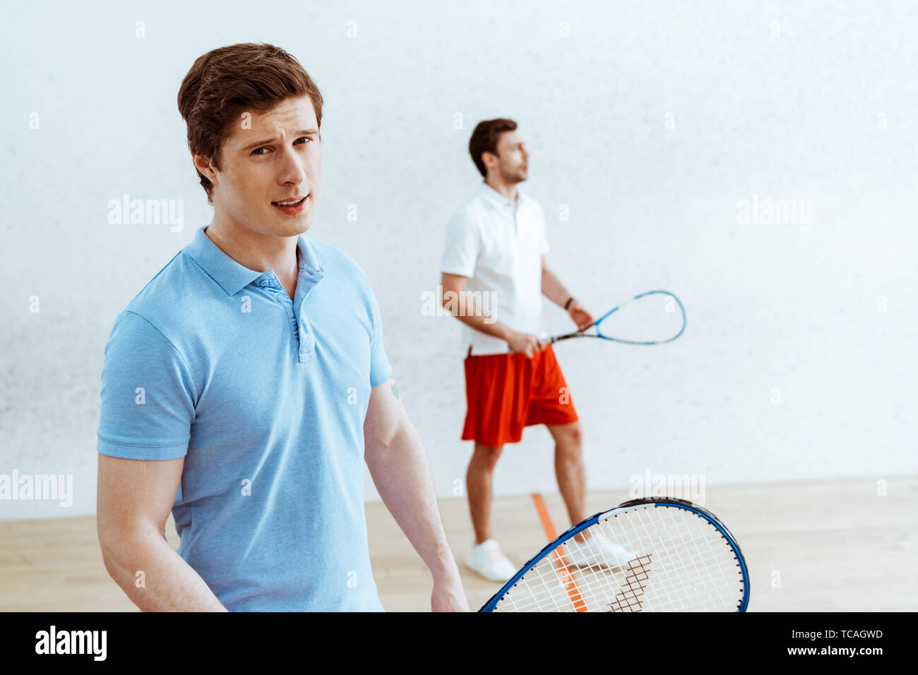Handsome squash player in blue polo shirt looking at camera Stock Photo ...