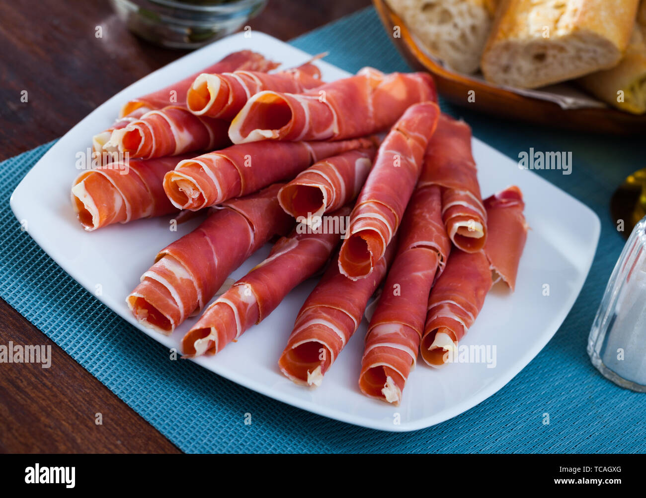 Traditional Spanish dish – jamon served in form of tubes on platter ...