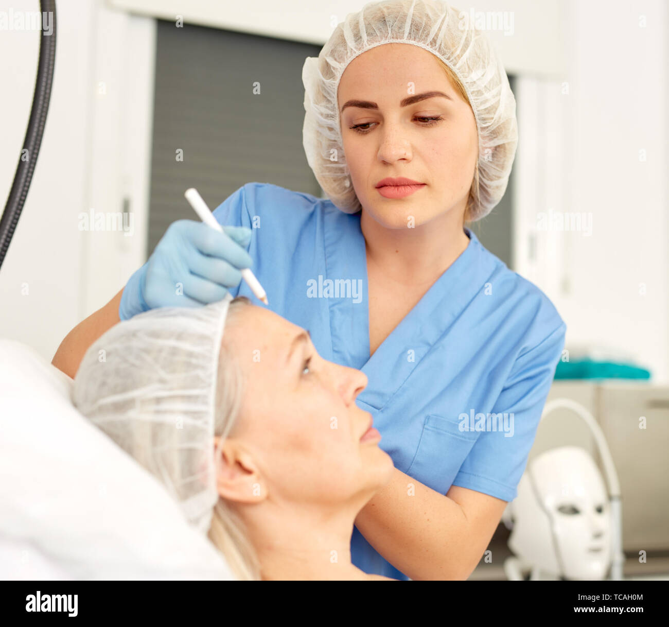 Plastic surgeon preparing for operation on mature woman face Stock ...