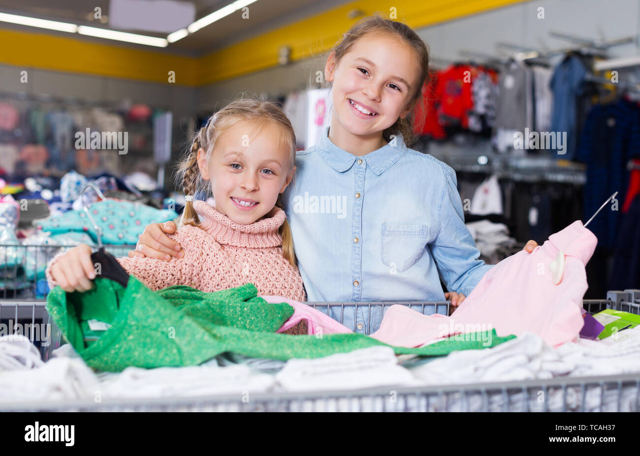 two happy little girls with new clothes in shopping mall Stock Photo ...