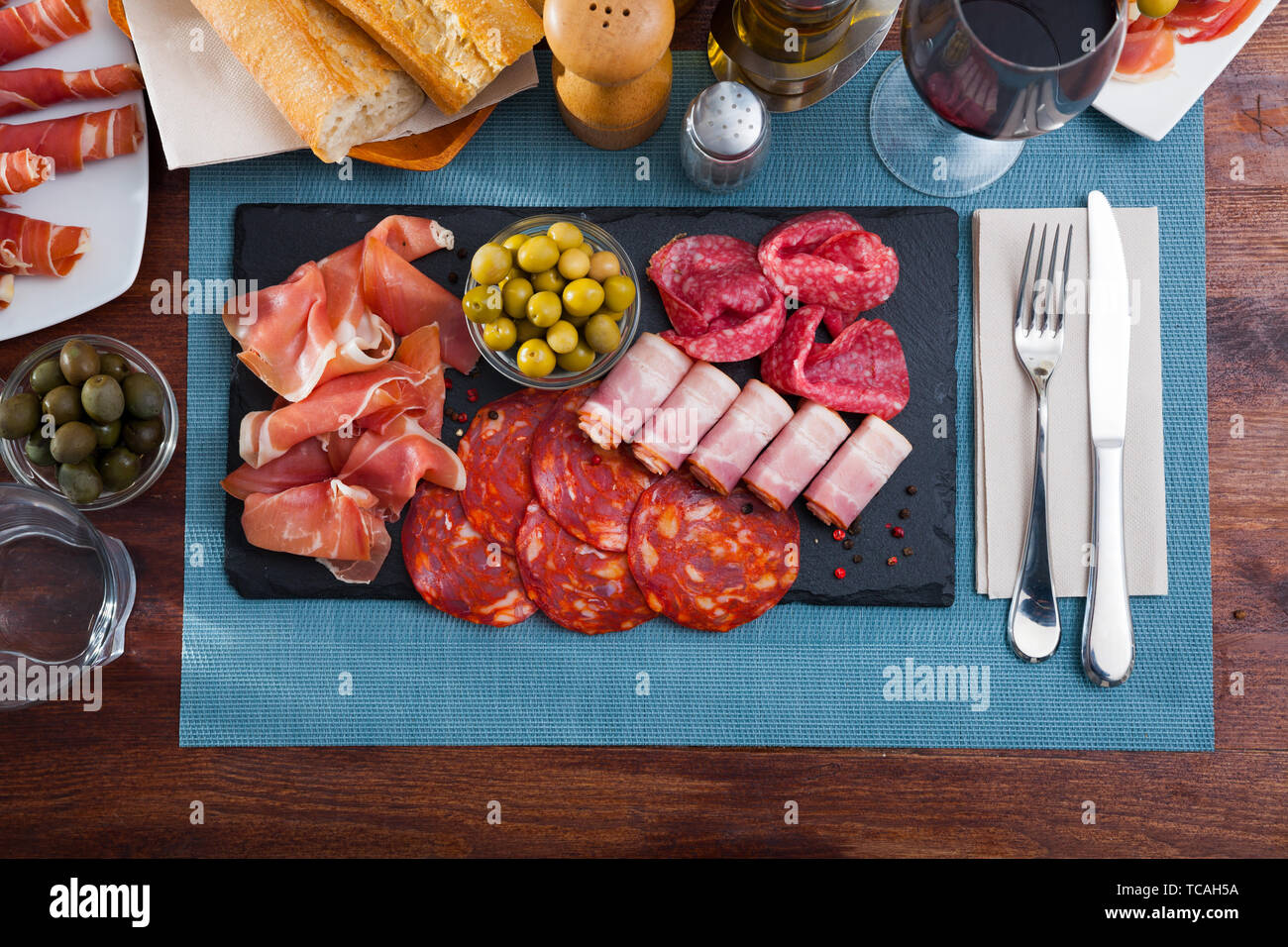 Top view of meat platter - sliced dry-cured jamon, bacon, chorizo and ...