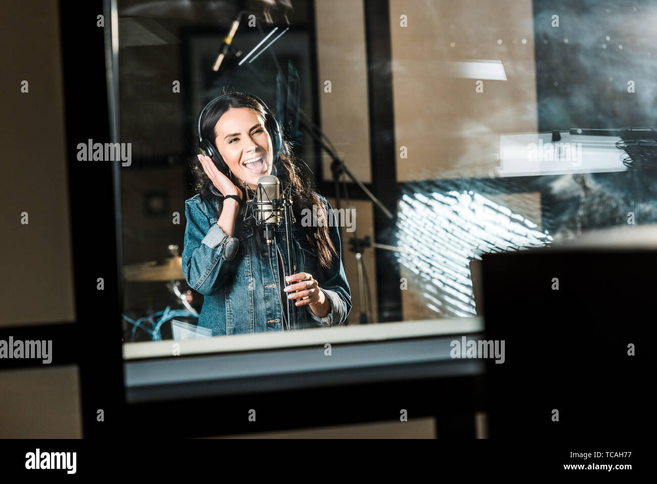 beautiful, inspired musician singing near microphone in recording ...