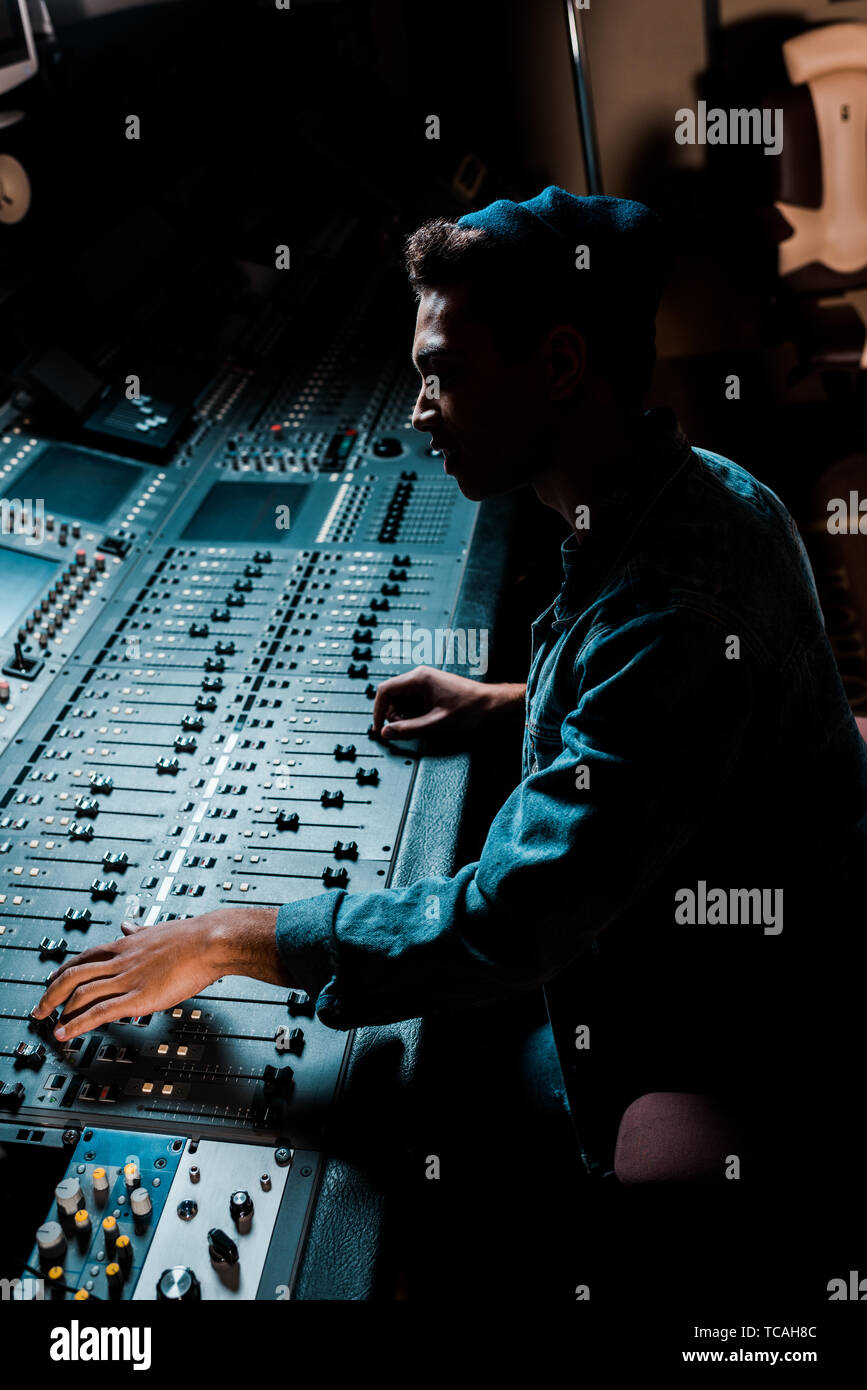 sound producer working at mixing console in dark recording studio Stock ...
