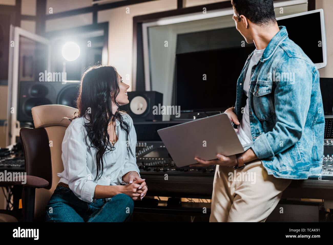 two multicultural sound producers working in recording studio together ...