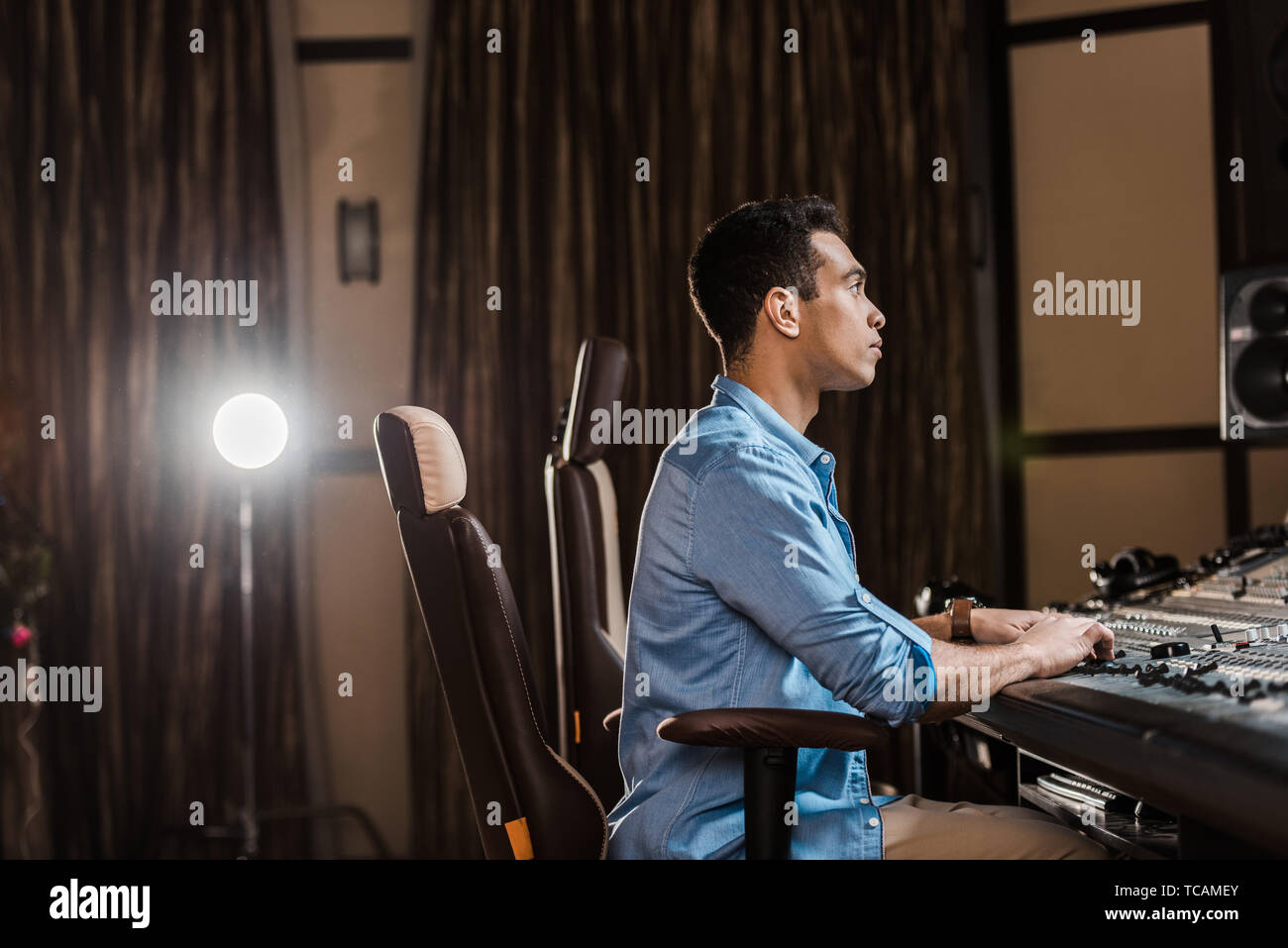 concentrated sound producer sitting in office chair and working at ...